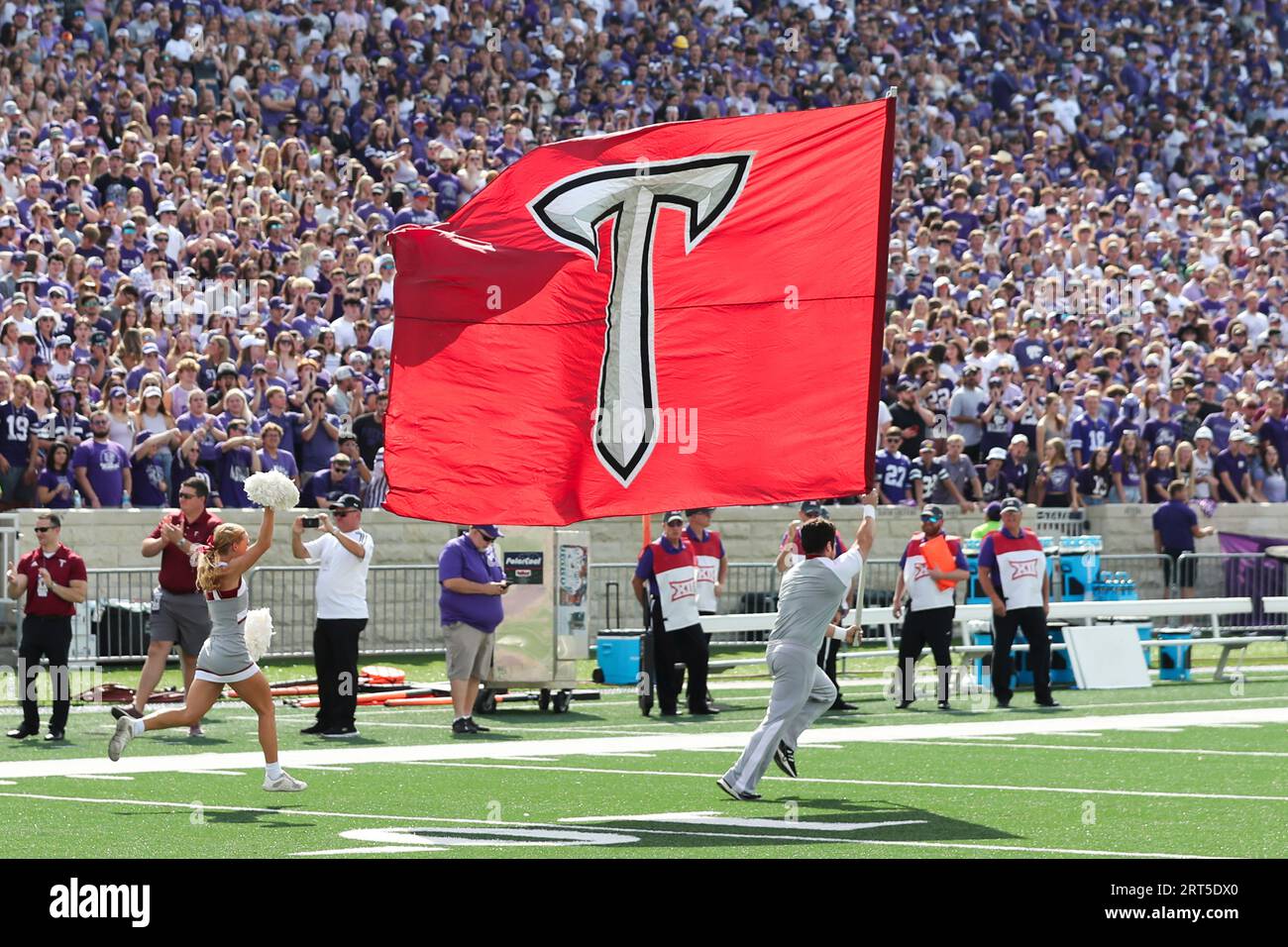 MANHATTAN, KS - SEPTEMBER 09: A cheerleader runs onto the field with a ...