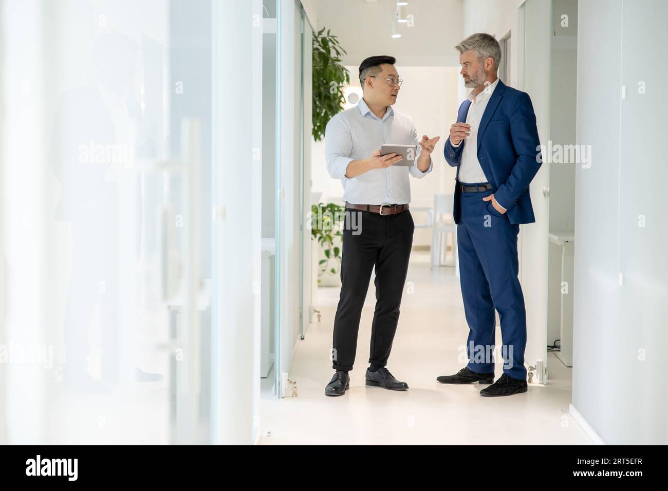 Men standing in corridor in office and talking about their work Stock ...
