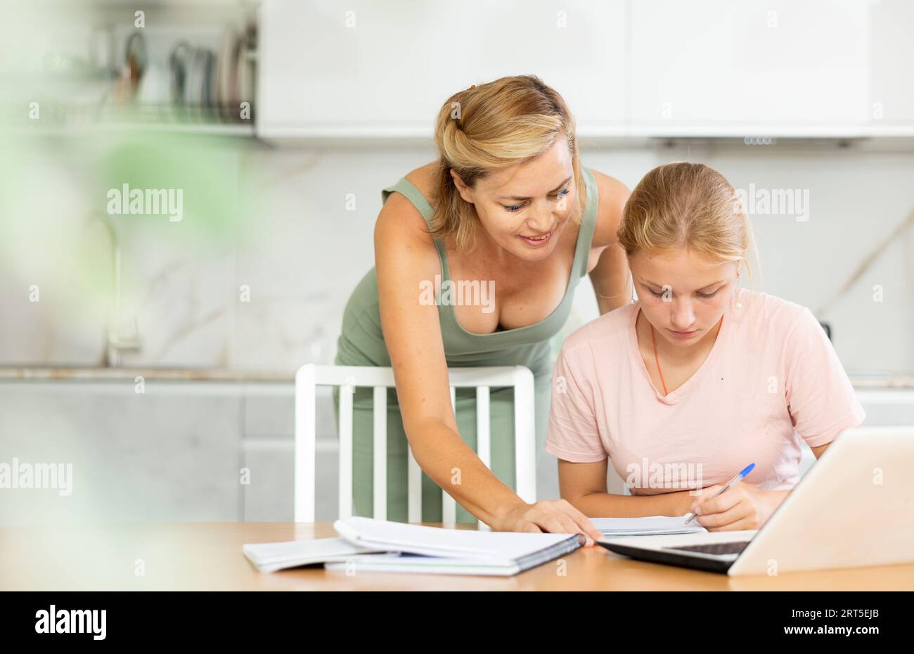 Teenage girl studying at home guided by friendly female tutor Stock ...