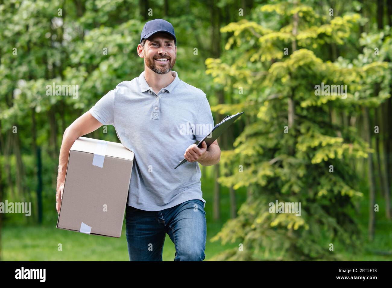 Courier man delivering package to client home Stock Photo - Alamy