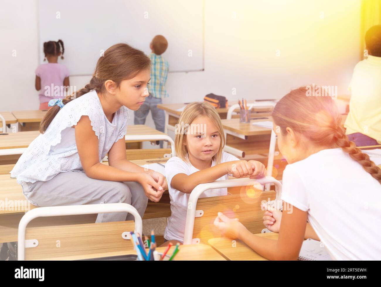 Cheerful preteen classmates talking at recess between lessons Stock ... Cheerful preteen classmates talking at recess between lessons Stock ...