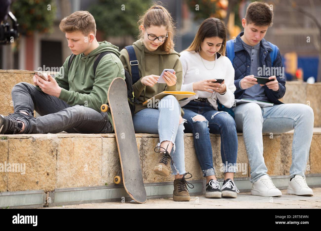 Teens using smartphones outdoors hi-res stock photography and images ...
