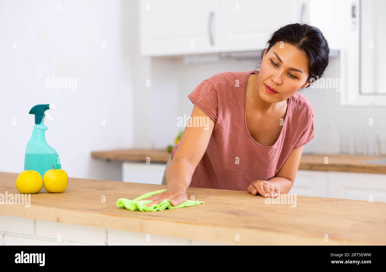 Woman cleaning table with rag at home Stock Photo - Alamy