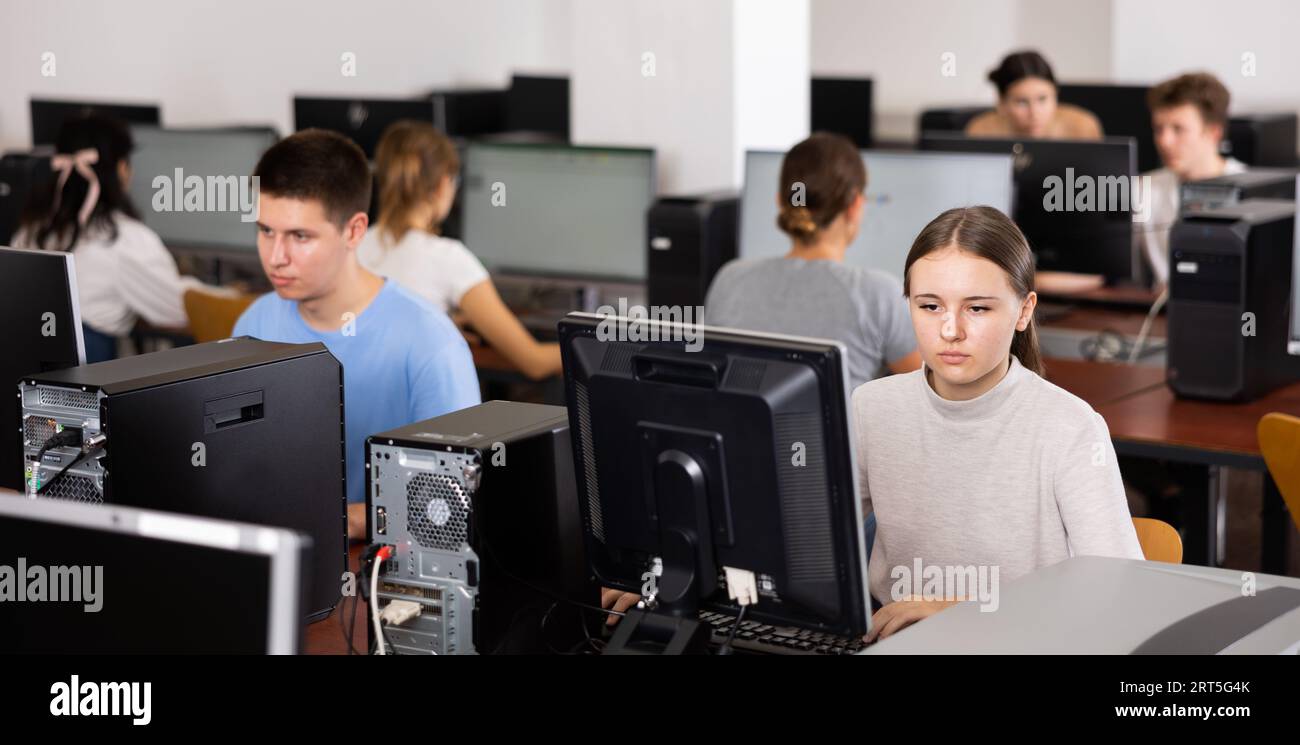 Interested teen girl studying with classmates in school class Stock ...