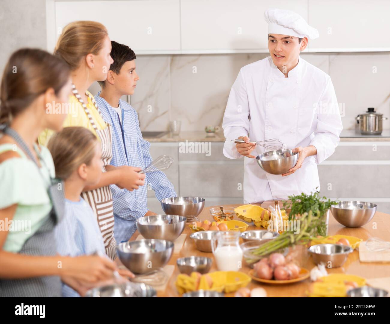 Young chef giving culinary classes to group of interested tweens Stock ...