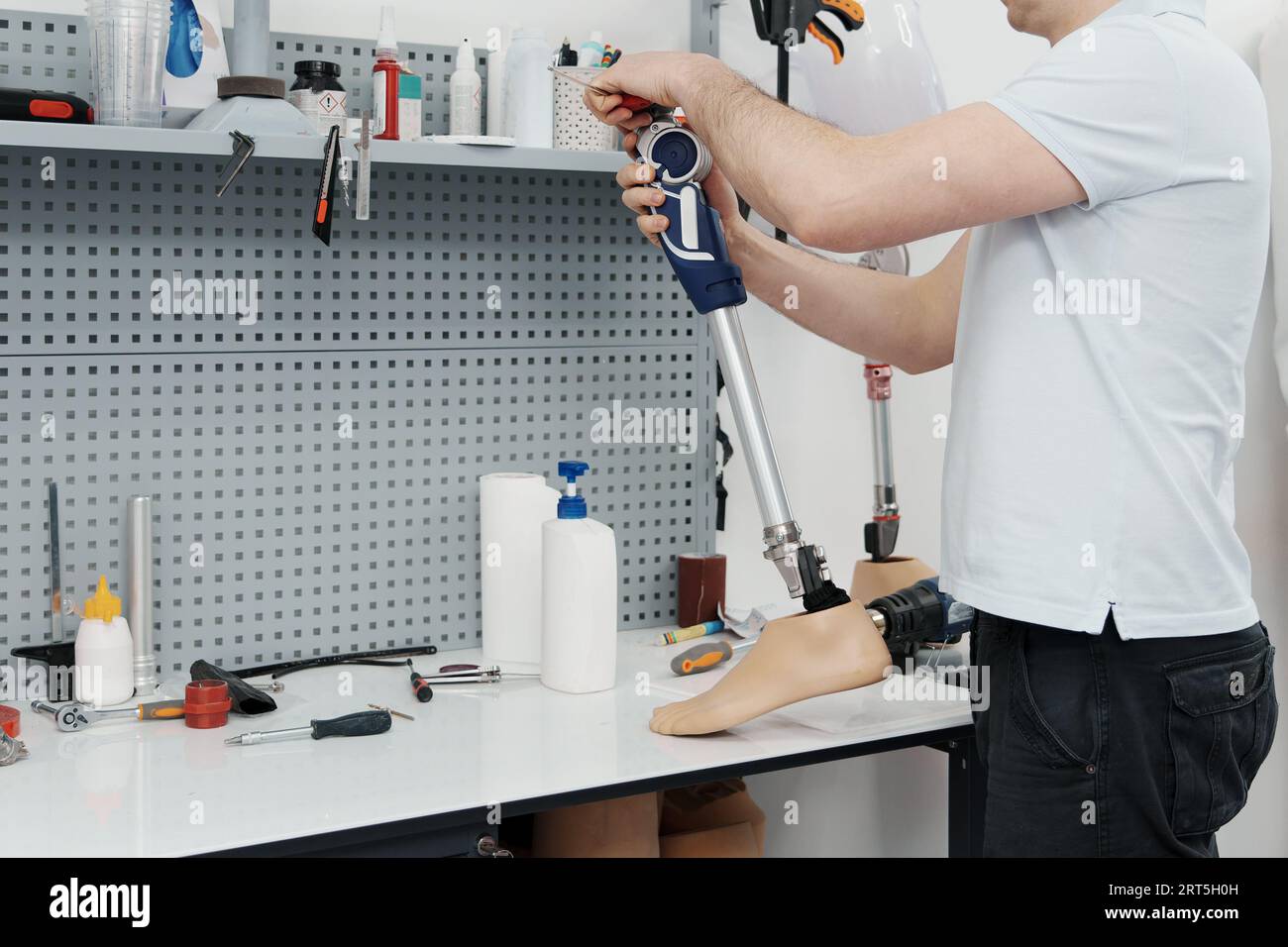Crop unrecognizable craftsman adjusting and bending modern prosthetic ...