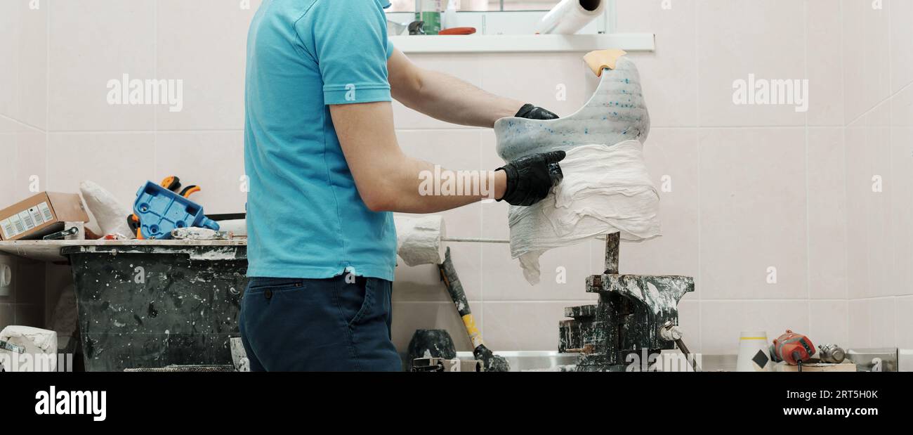 Male worker in black rubber gloves making hip disarticulation ...