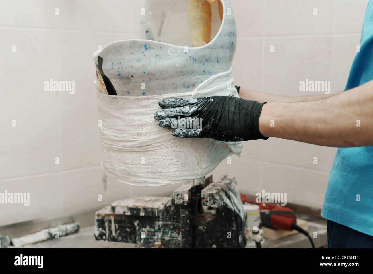 Male worker in black rubber gloves making hip disarticulation ...