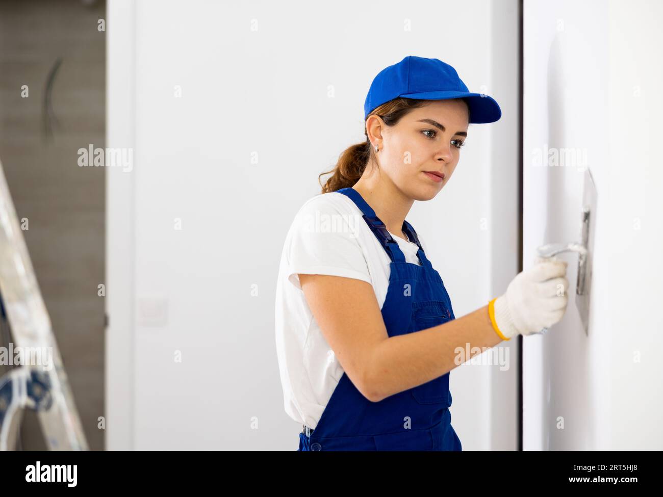 Woman builder using floated trowel to daub plaster to wall Stock Photo ...