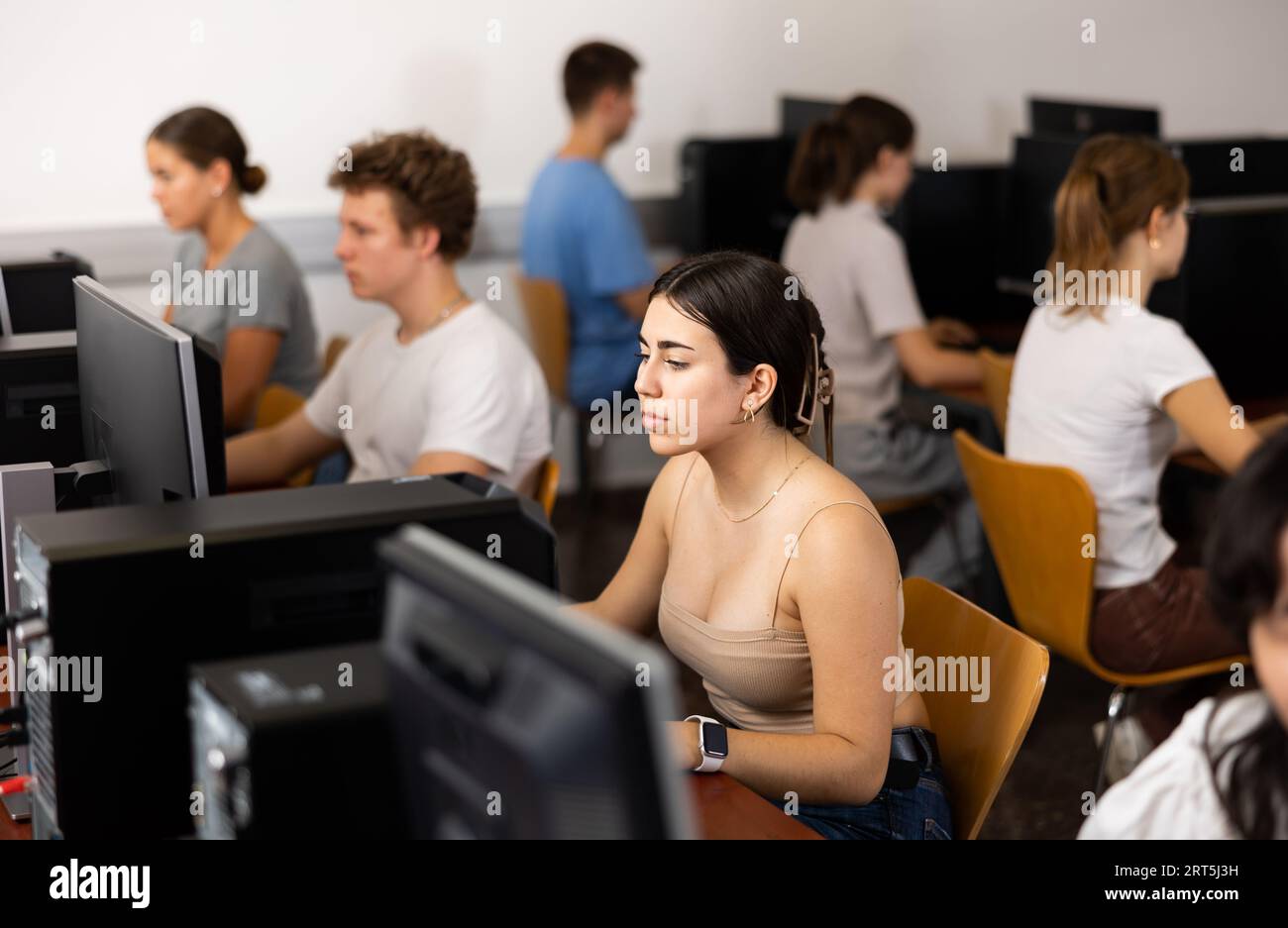 Group of young smart students studying together in computer class ...