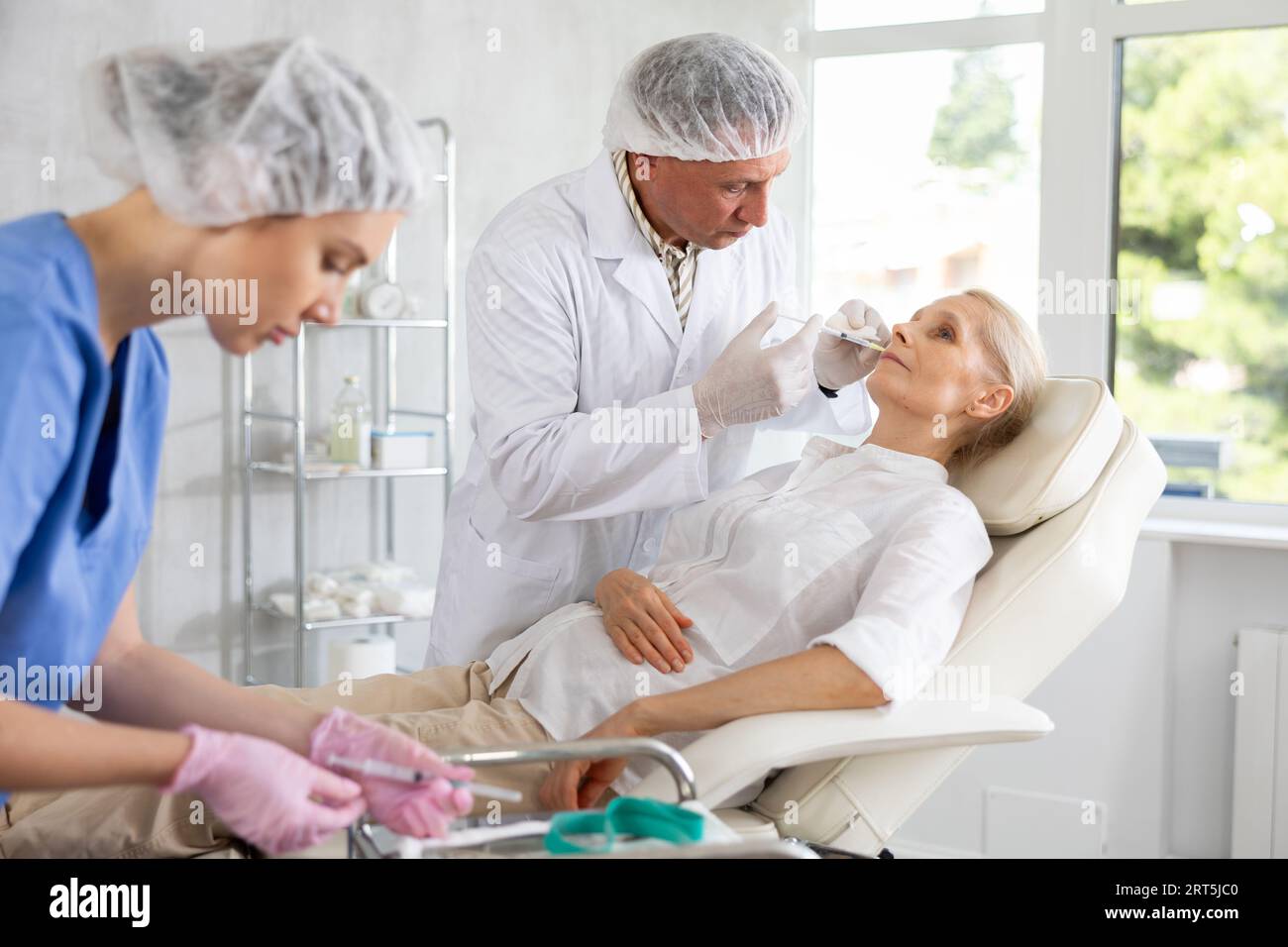 Elderly woman getting procedure of injection contouring and for facial ...