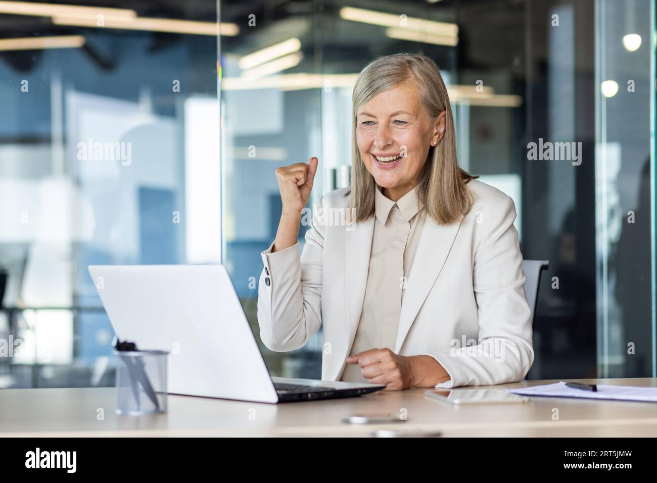 Senior successful business woman celebrating victory success, gray ...