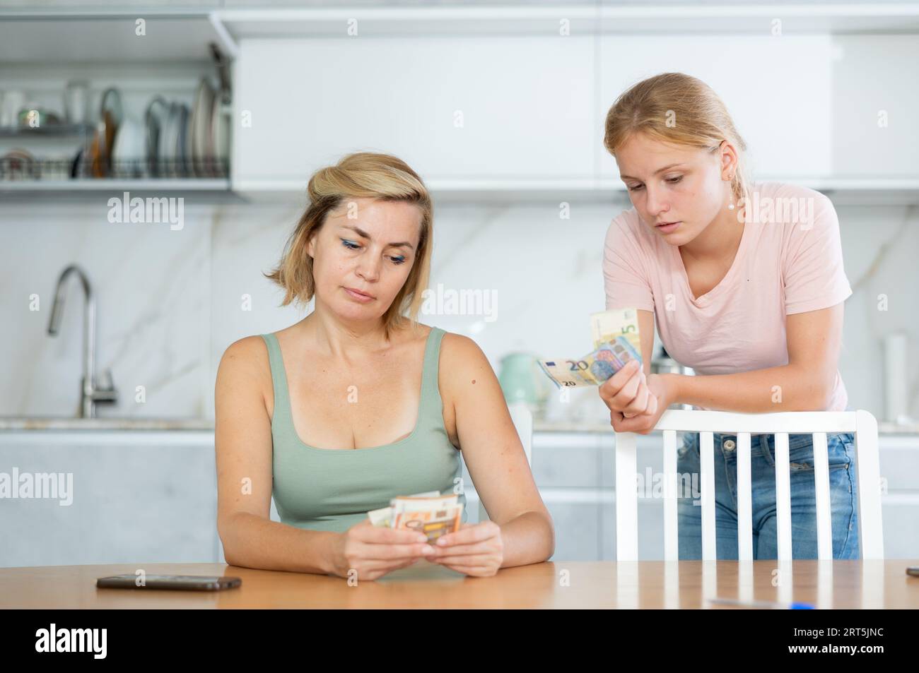 Teenage girl asking for pocket money from mother counting received ...