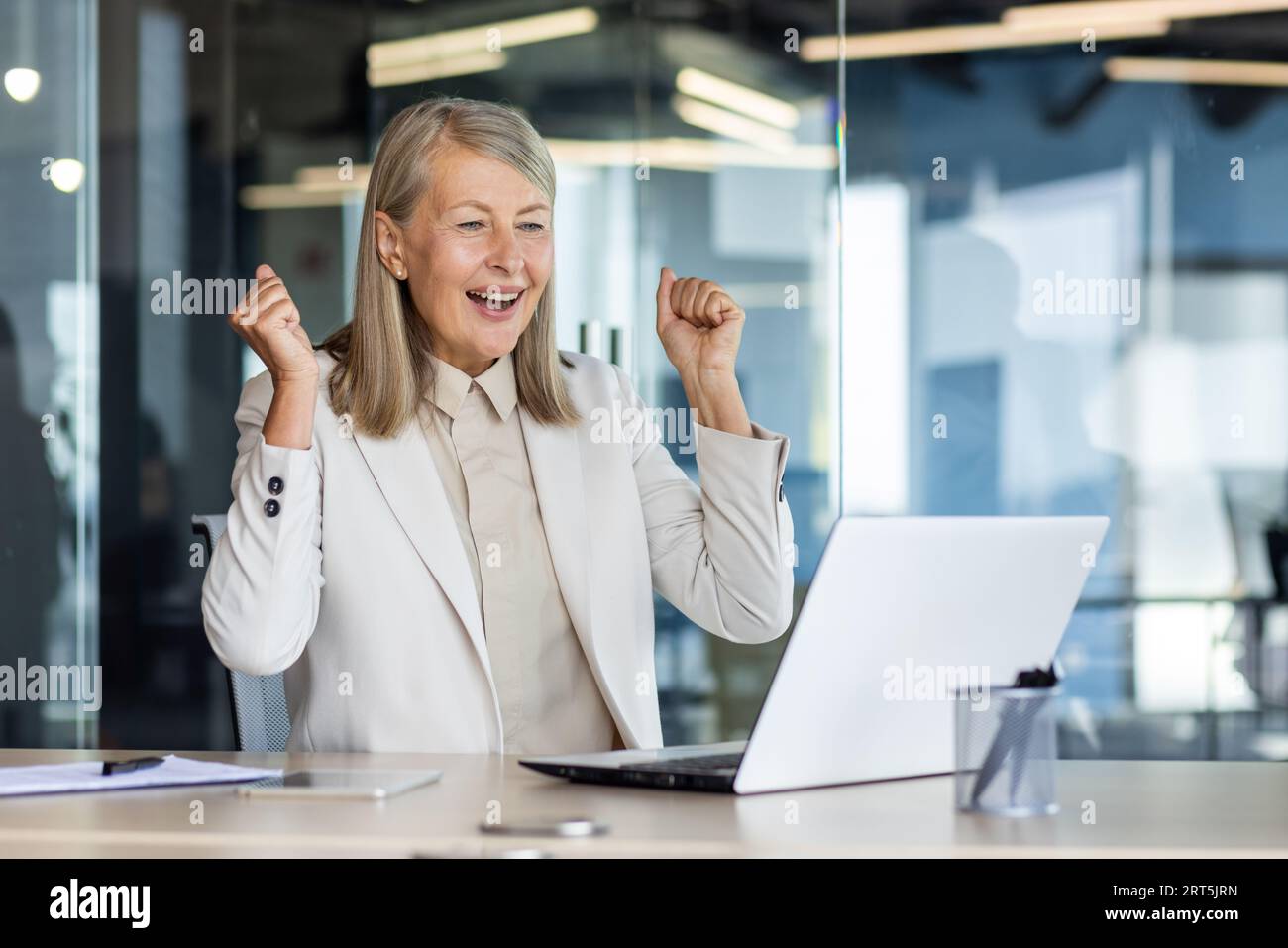 Senior successful business woman celebrating victory success, gray ...