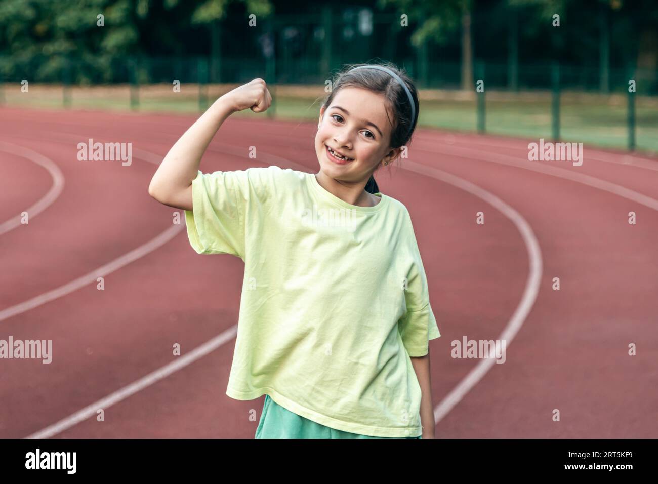 Strong little girl posing outdoors showing their muscles Stock Photo ...