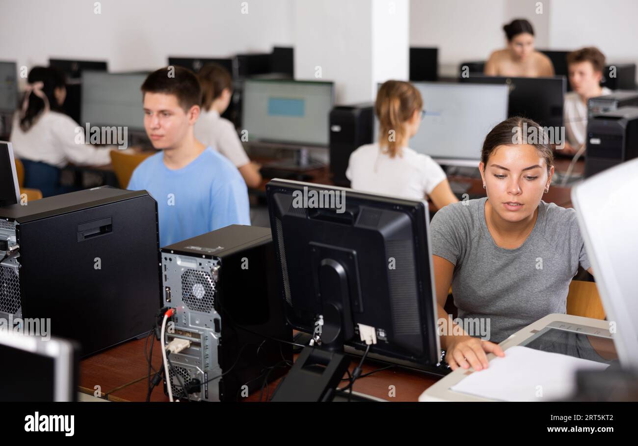 Smart female teenager learning computer science while she is using a PC ...