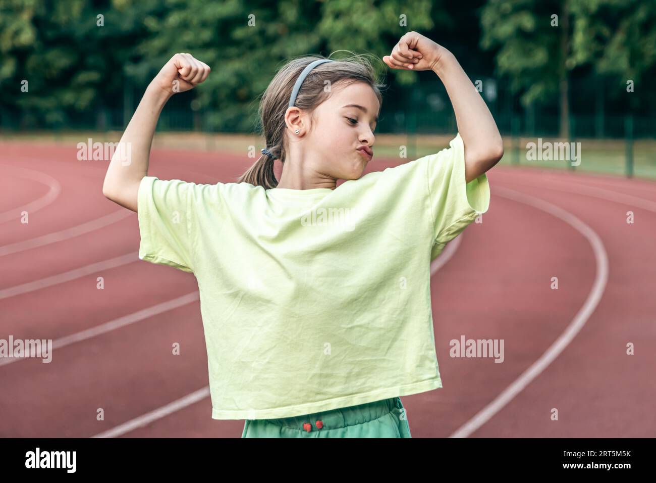 Strong little girl posing outdoors showing their muscles Stock Photo ...
