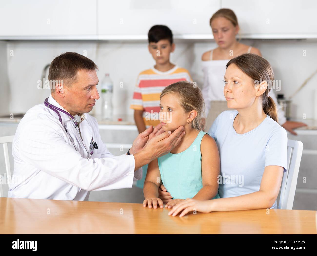 Man doctor examines throat and lymph nodes of small girl patient at ...