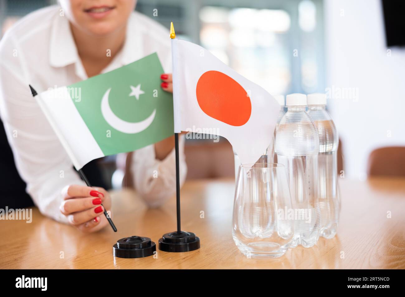 Flags of Pakistan and Japan in female hands in meeting room Stock Photo ...