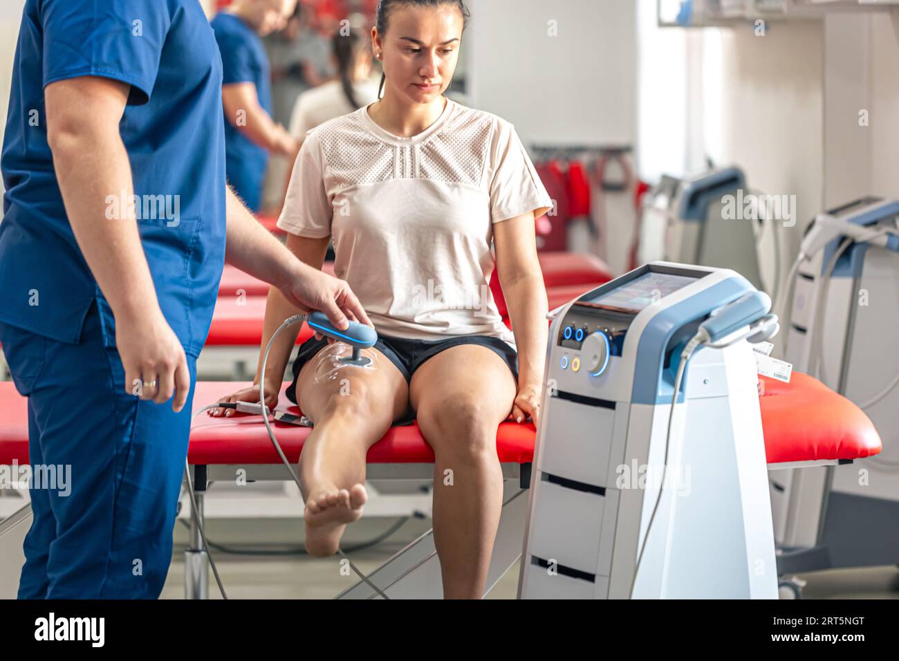 Doctor using machine to treat the knee joints of a patient Stock Photo ...