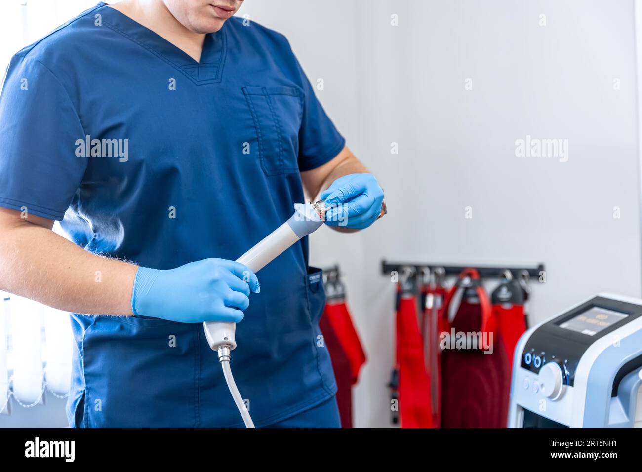 Shock wave therapy device with male doctor hands in rubber gloves Stock ...