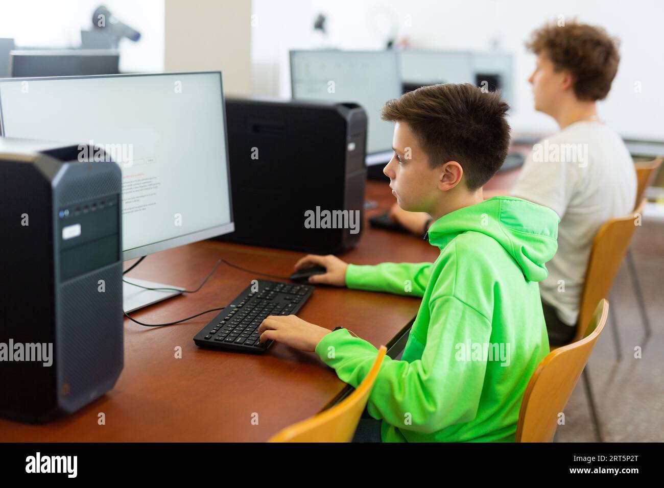 Preteen boy learning basics of programming in computer college Stock ...