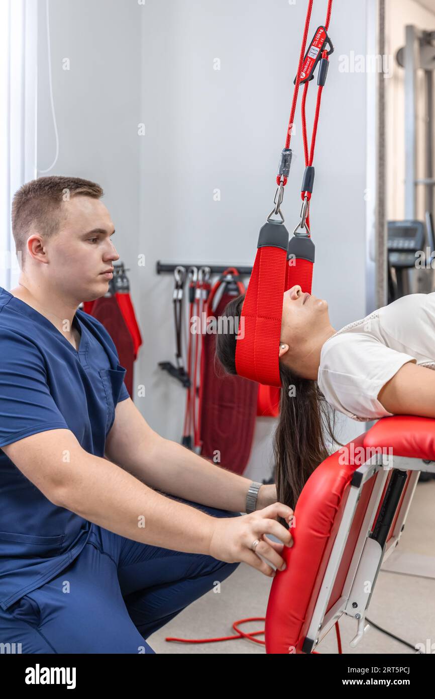 Female patient hanging on suspensions at rehabilitation center Stock ...