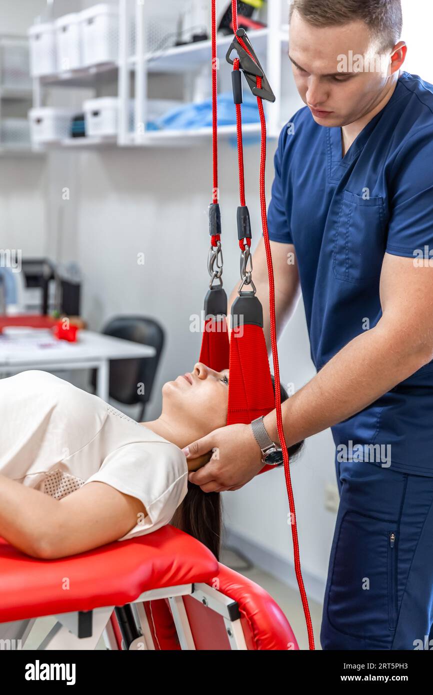 Female patient hanging on suspensions at rehabilitation center Stock ...