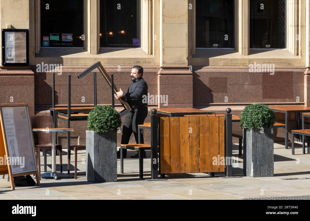 Man setting up outside tables at Viva Brazil restaurant on Castle ...