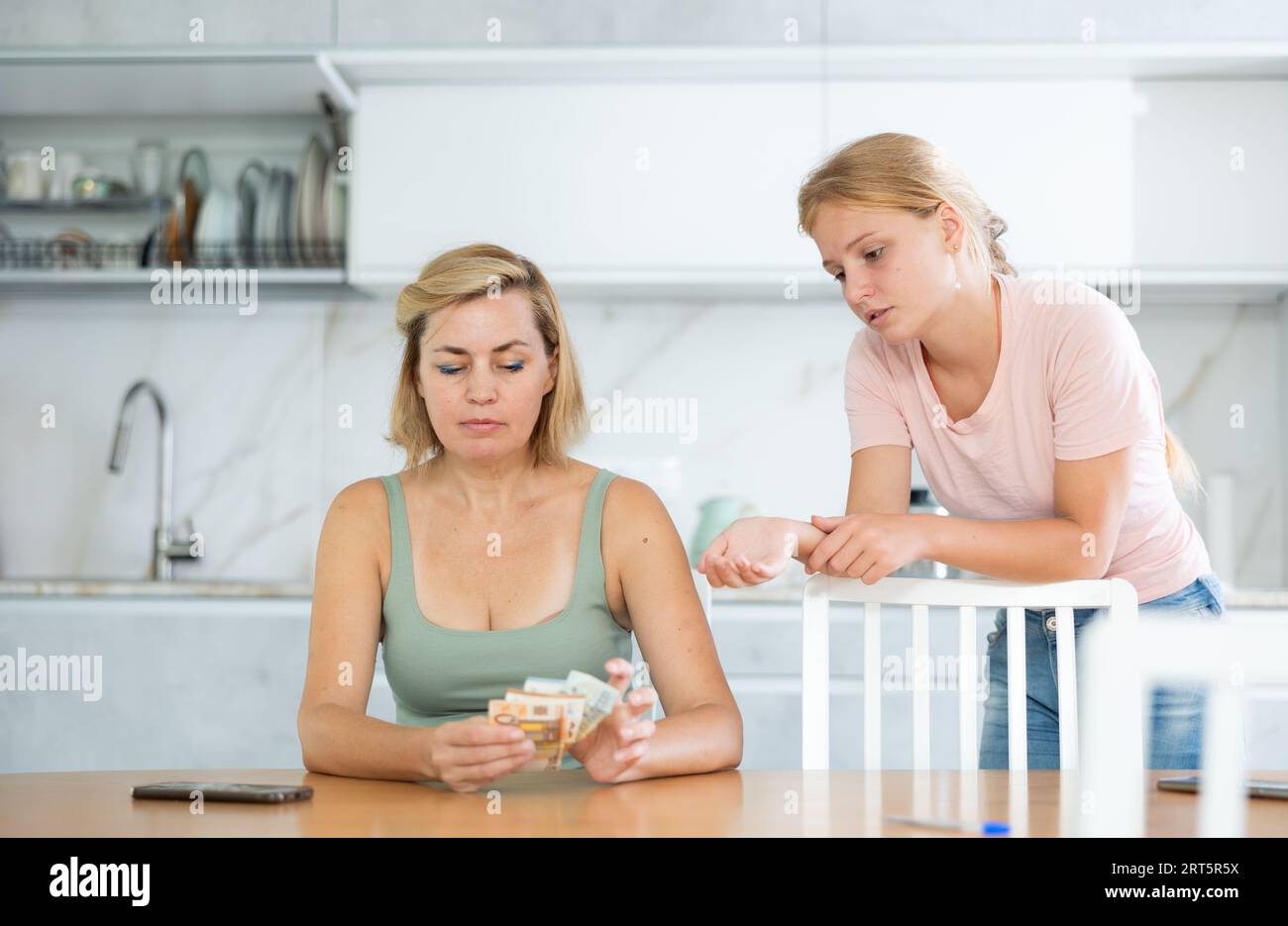 Teenage girl asking for pocket money from mother counting received ...