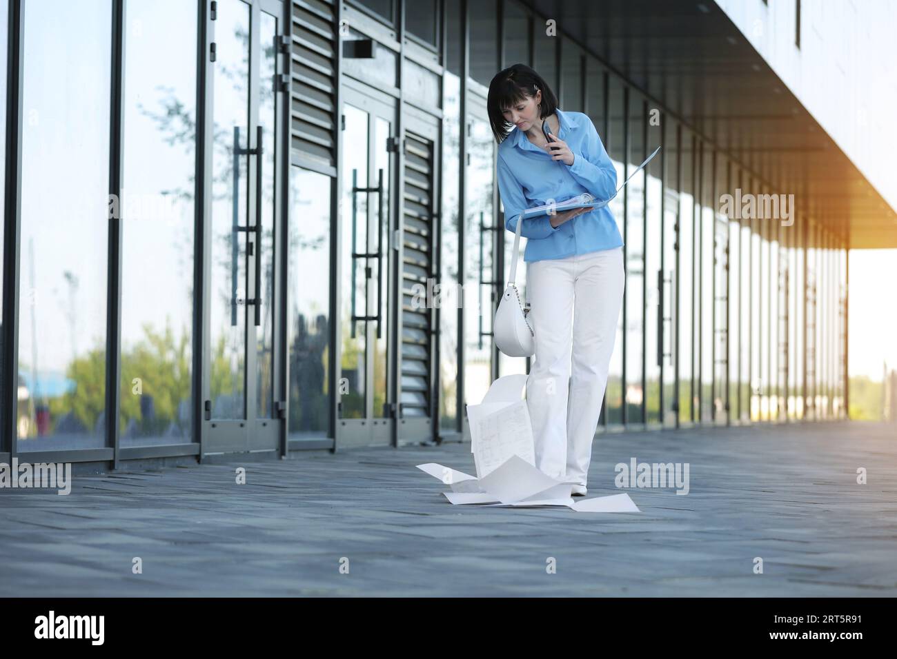 Multitasking busy young business woman communicates by smartphone ...