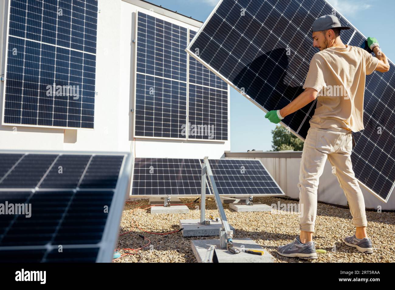 Man installing solar panels on a rooftop Stock Photo - Alamy