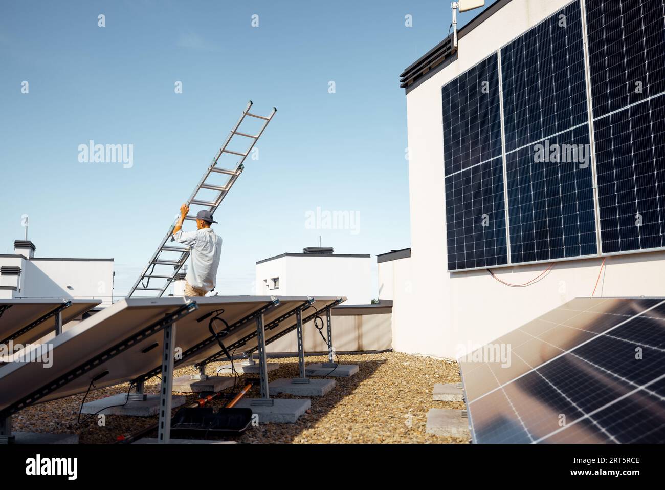 Man carries ladder during solar panels installation Stock Photo - Alamy