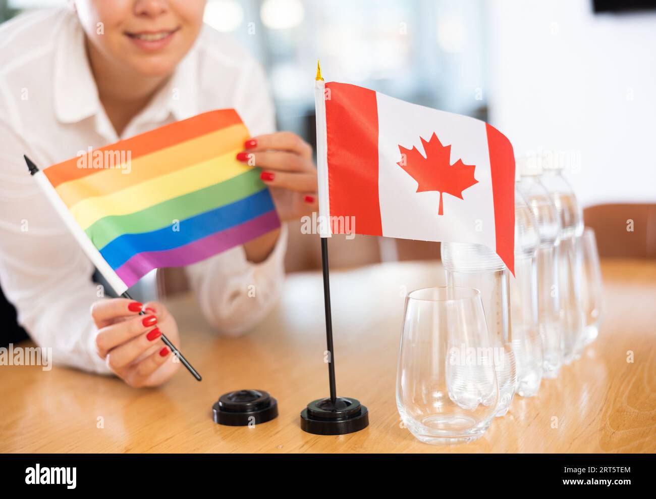 Unrecognizable girl sets midget flags of Canada and LGBT before ...