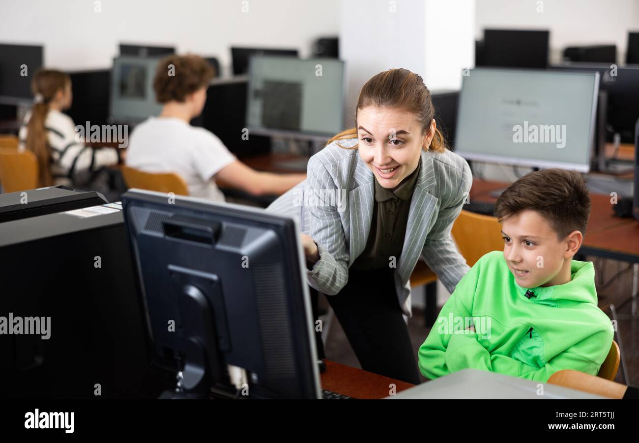 Female teacher and teenage boy looking at monitor of PC Stock Photo - Alamy