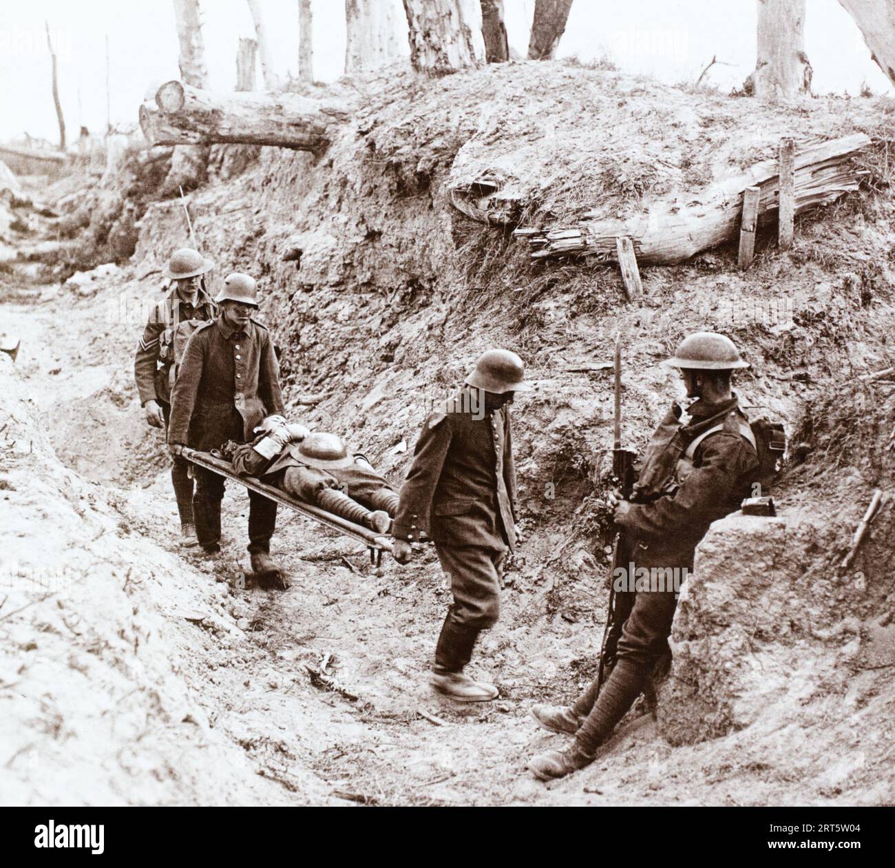 Captured German soldiers under guard carrying a wounded British soldier ...
