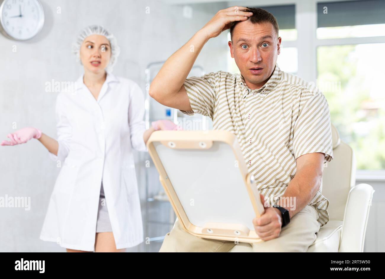 Dissatisfied man examines his face in mirror after plastic surgery ...