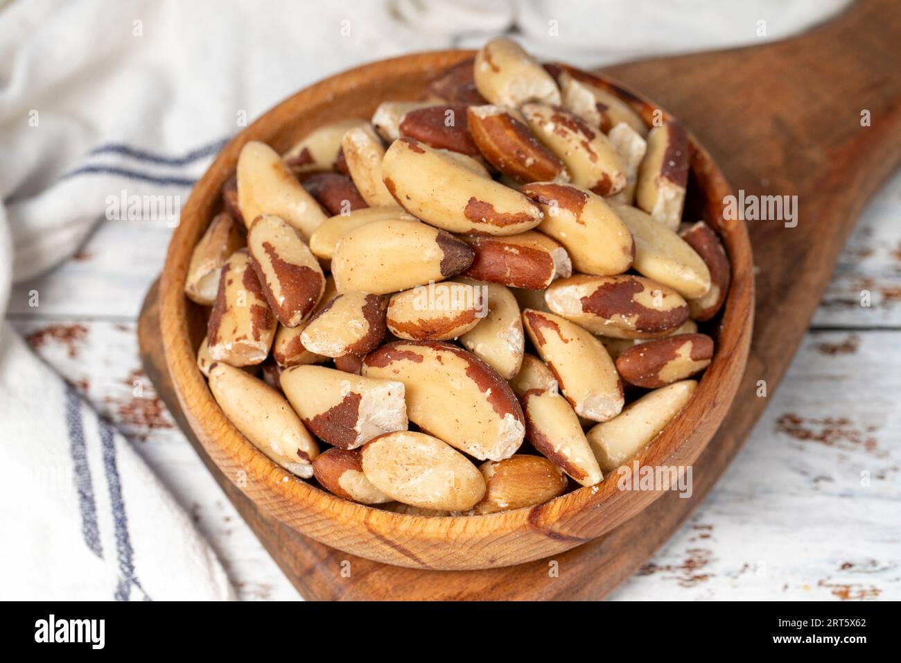 Brazil nut in wood bowl. Brazilian nuts peeled on white wood background ...