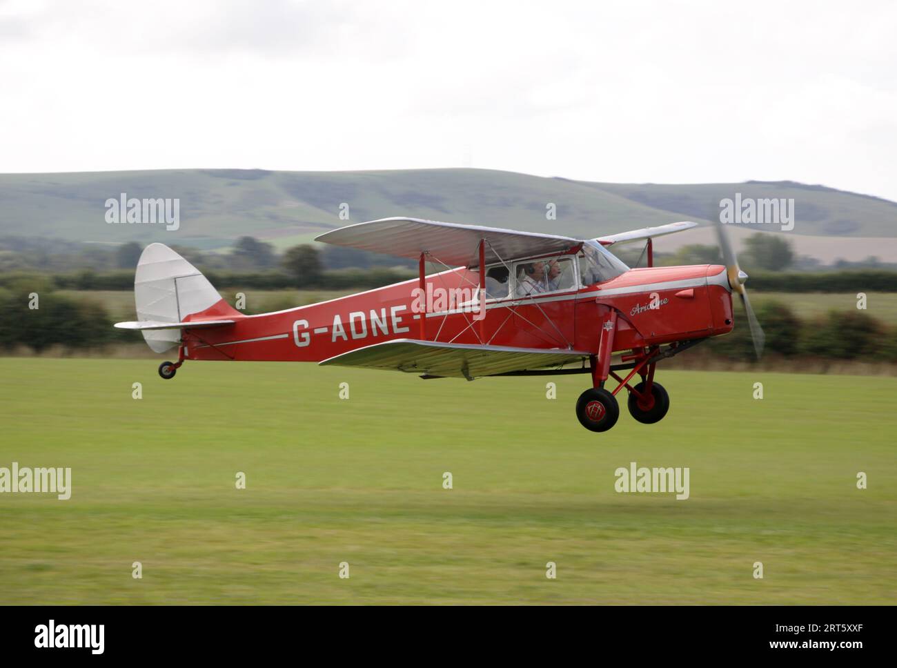 A De Havilland DH-87 Hornet Moth departs an airfield in East Sussex ...