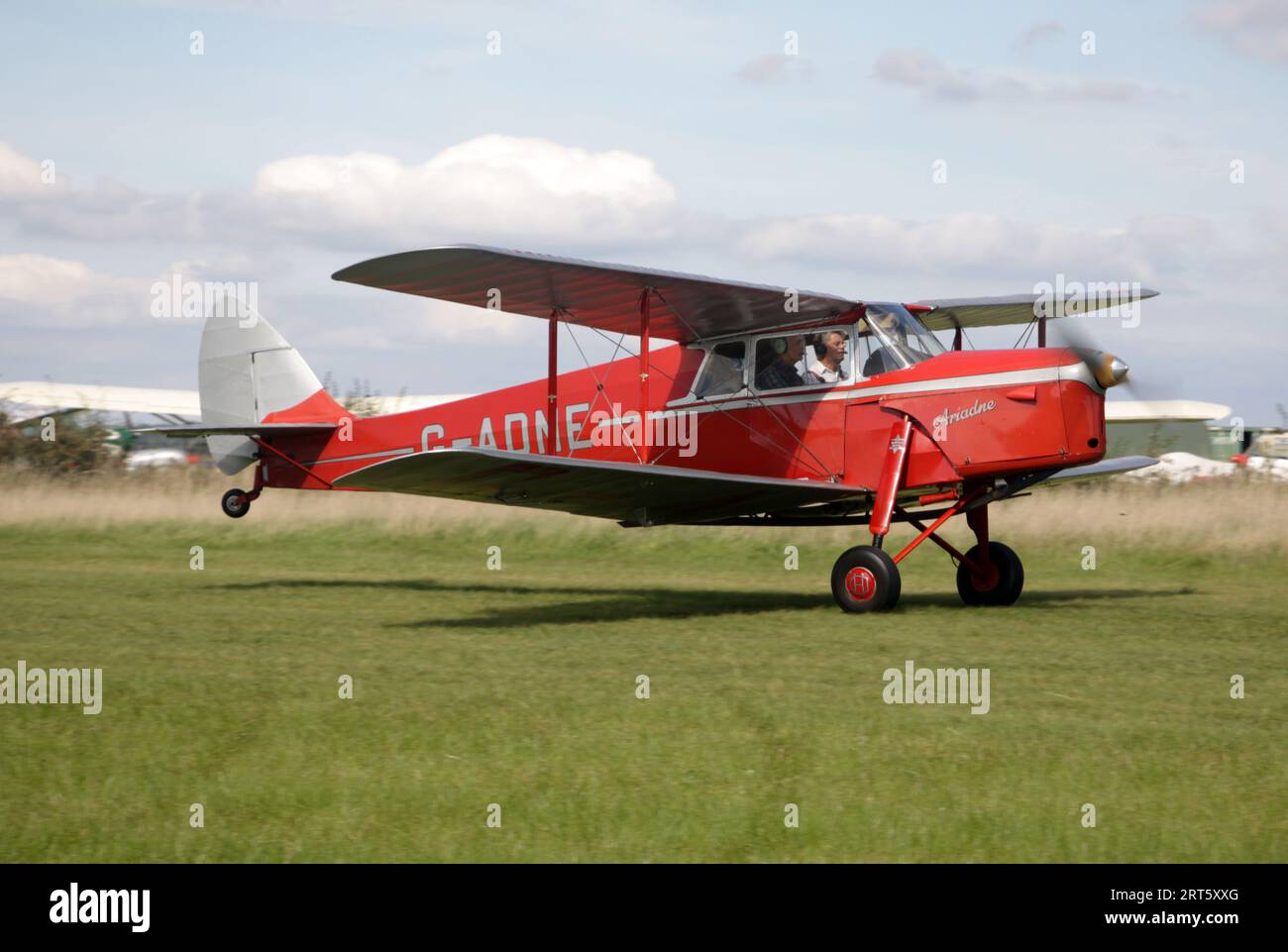 A De Havilland DH-87 Hornet Moth departs an airfield in East Sussex ...