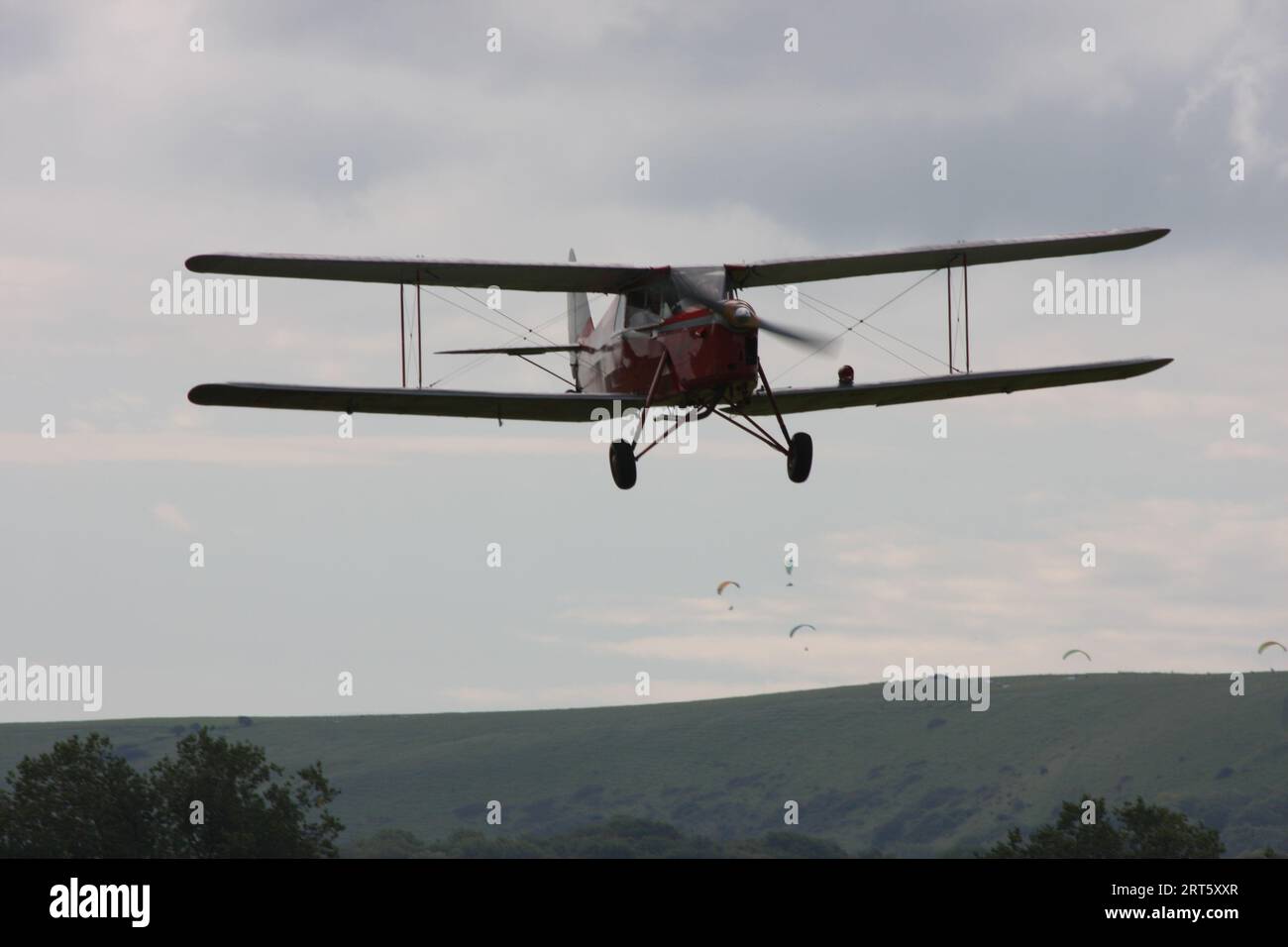 A De Havilland DH-87 Hornet Moth departs an airfield in East Sussex ...