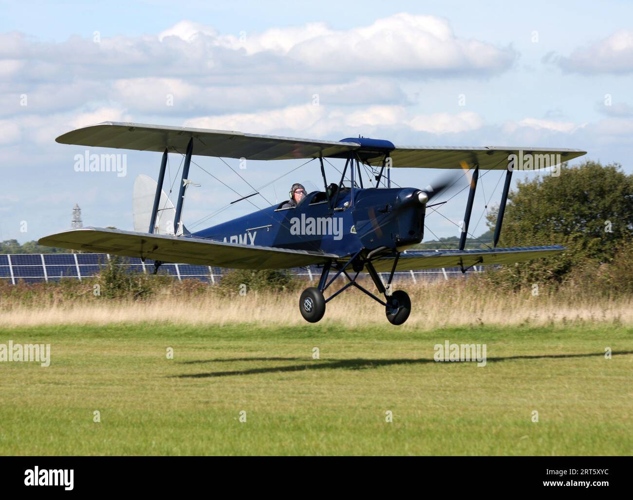 A De Havilland DH-82 Tiger Moth departs an airfield in East Sussex ...