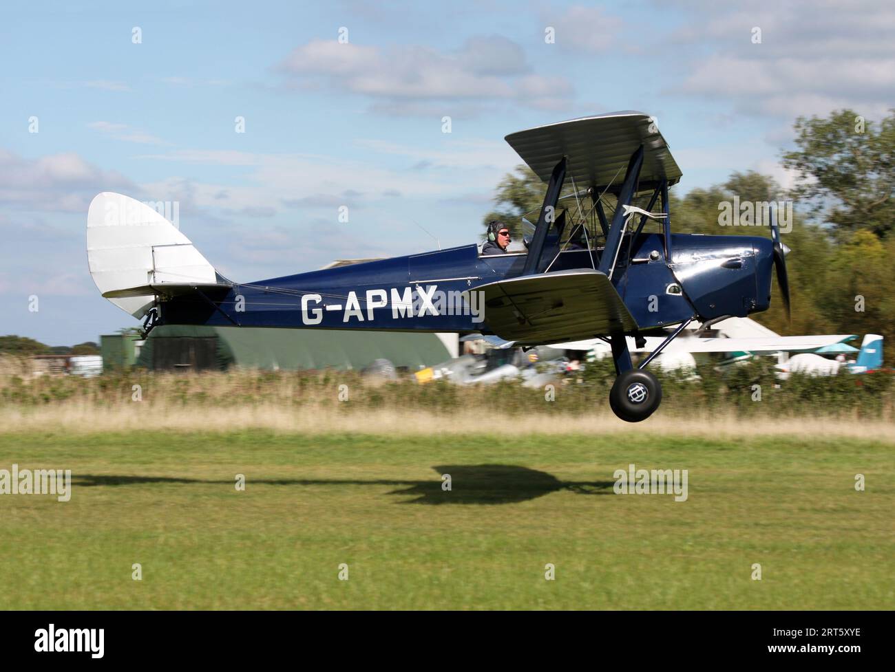 A De Havilland DH-82 Tiger Moth departs an airfield in East Sussex ...
