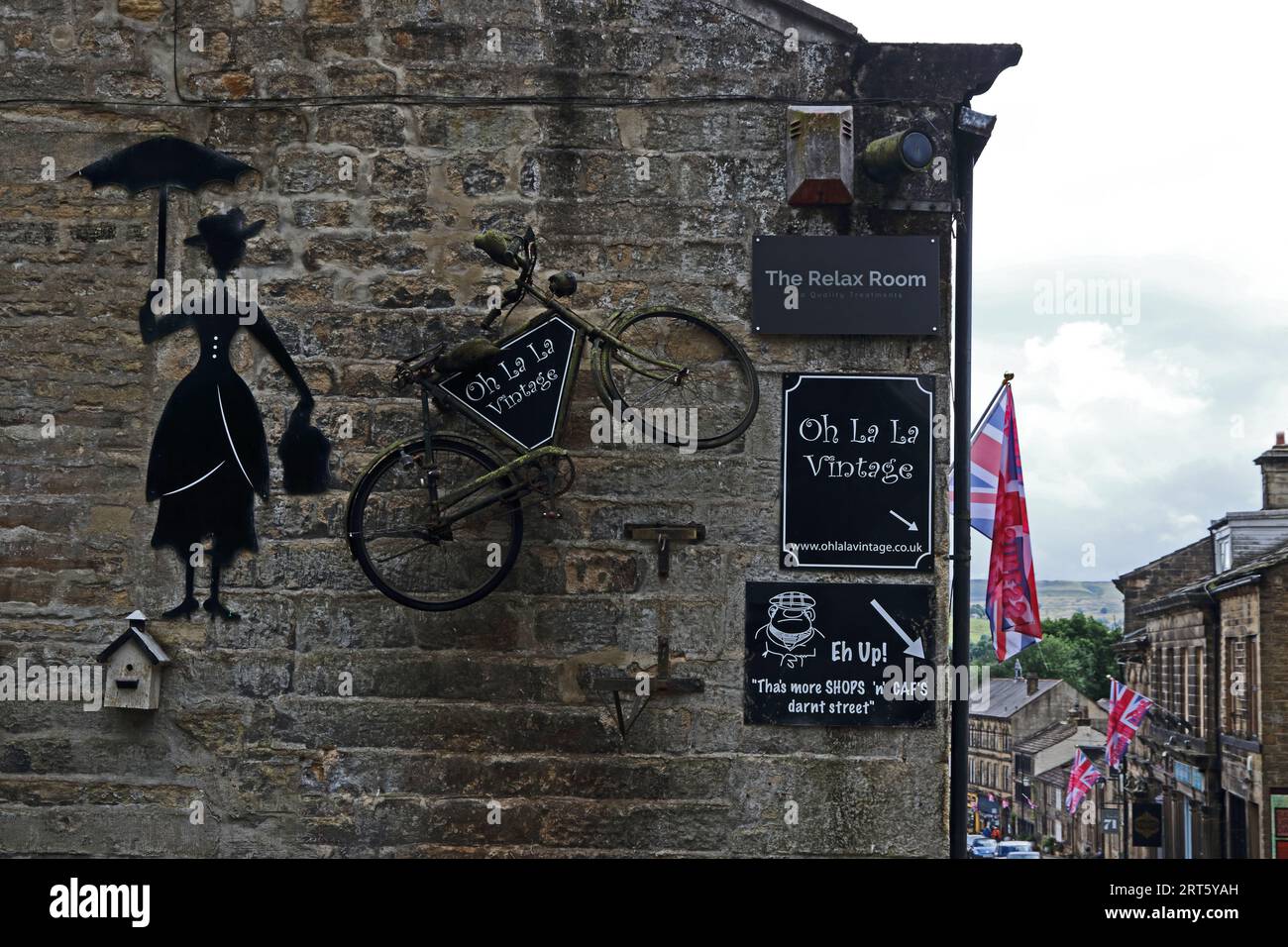 Bicycle and signs hung on end wall of terrace of shops, Howarth Stock ...