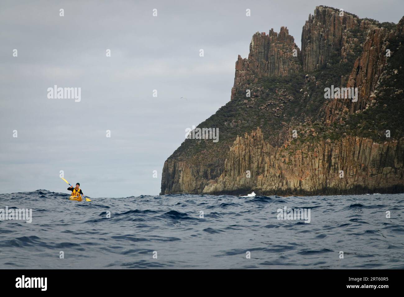 A sea kayaker paddles around Cape Pillar, Tasman Peninsula, Tasmania ...