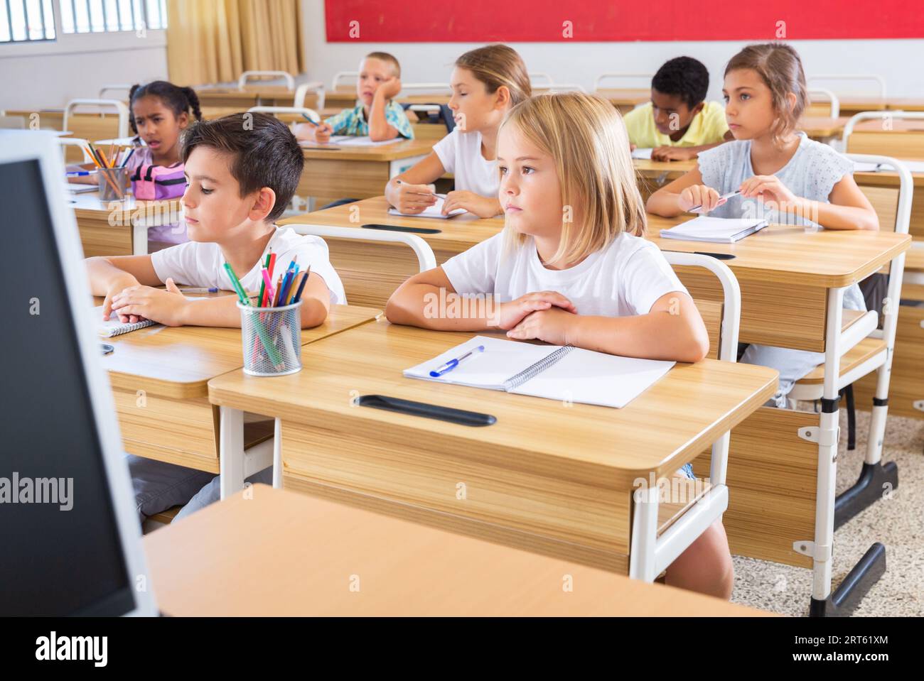 Focused preteen pupils studying in classroom with female teacher Stock ...