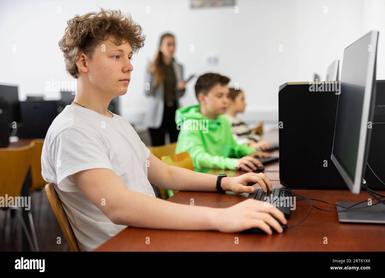 Teenage boy learning to use personal computer during lesson Stock Photo ...
