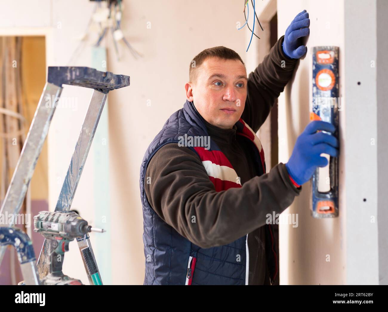 Repair man measuring evenness of wall Stock Photo - Alamy