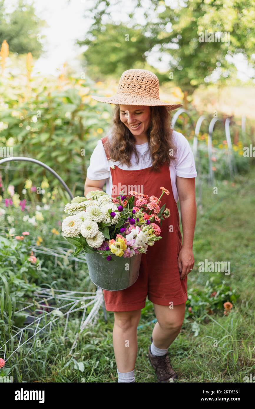 A woman carrying a bouquet of fresh flowers from her cut flower Stock ...