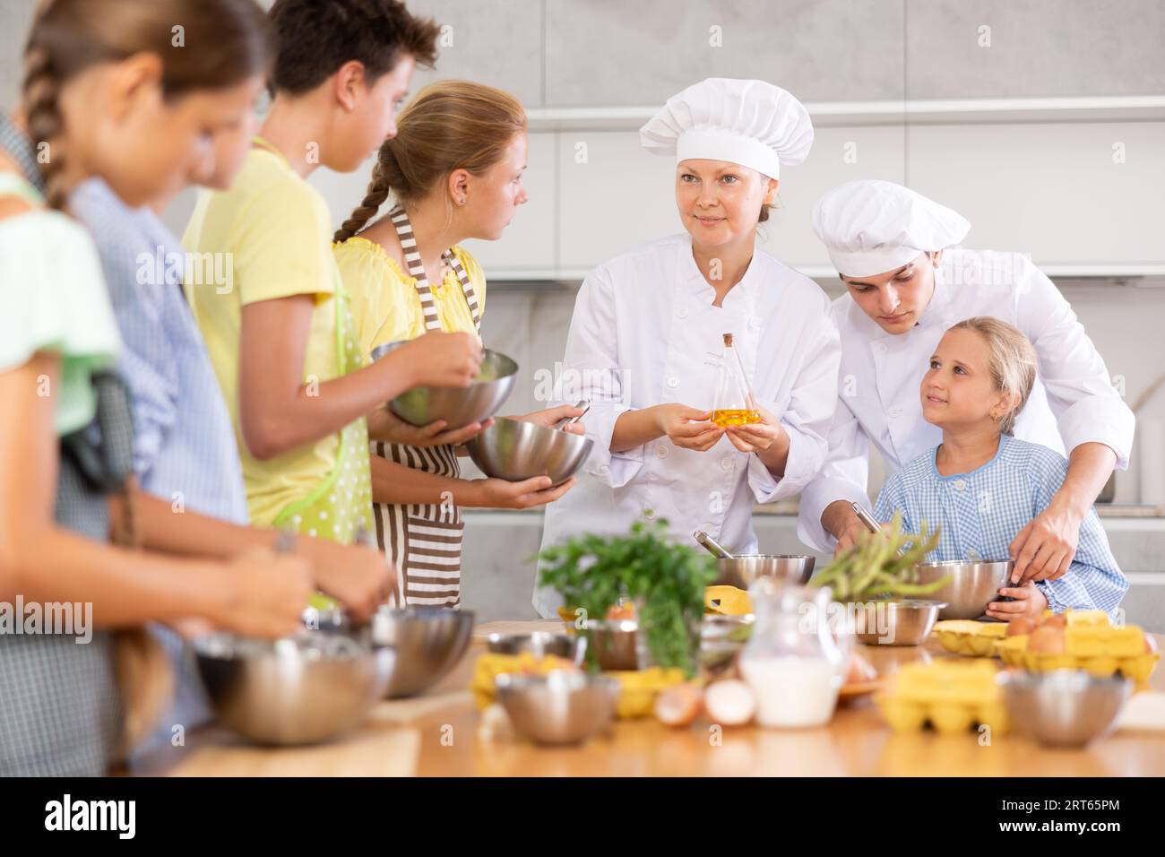 Two friendly chefs giving culinary lesson to group of tweens Stock ...